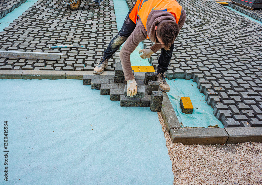 Interlocking concrete pavers being installed on a construction site ...