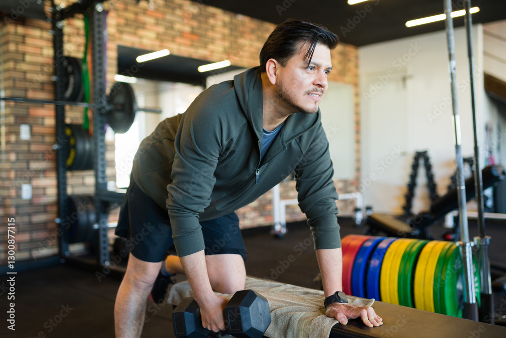 Overweight male performing bicep curls using free weights during ...