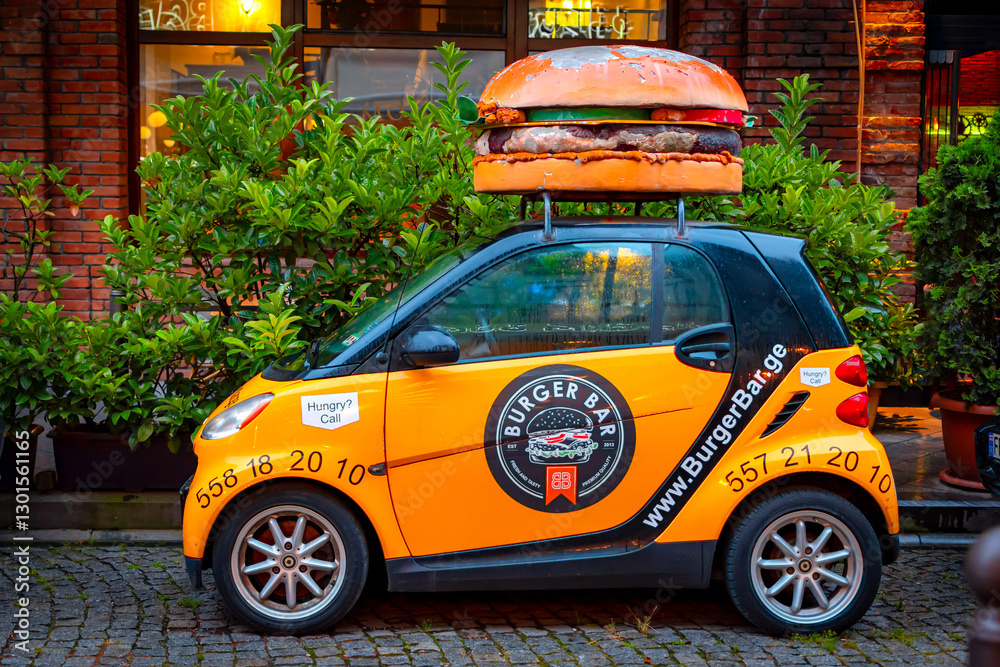 Georgia, Tbilisi, june 2022. A vibrant burger delivery car with a giant ...