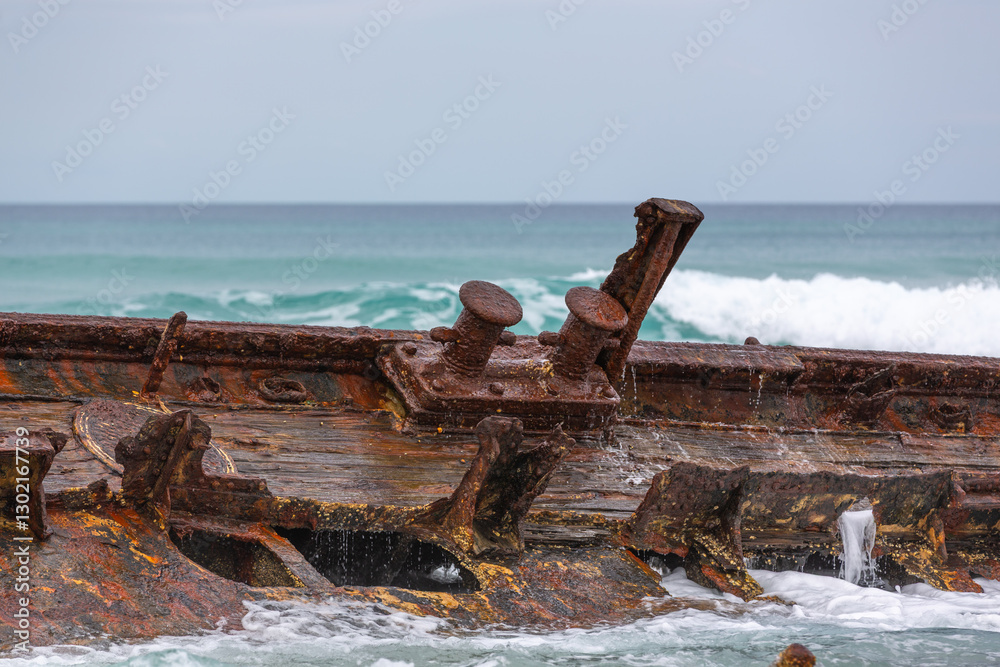 Rusty bollards and iron hull plates with the deteriorating deck timbers ...