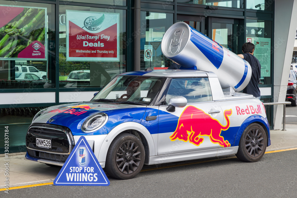 A Mini Cooper car decorated with the Red Bull logo and a giant can ...