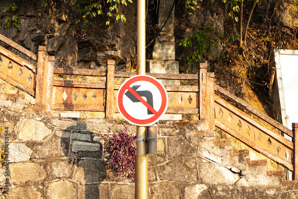 Don't left turn sign white aluminum circle by concrete wall and stairs ...