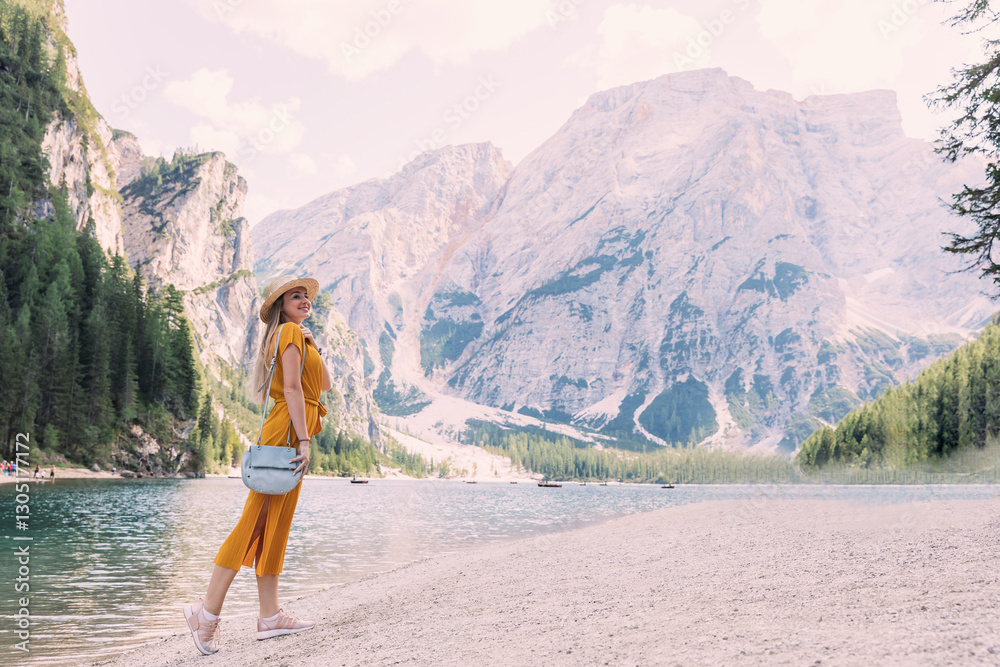 woman enjoys fresh air at Lago di Braies. girl in yellow dress and ...