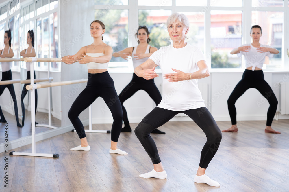 Group of slender women of different ages are learning various dance and ...