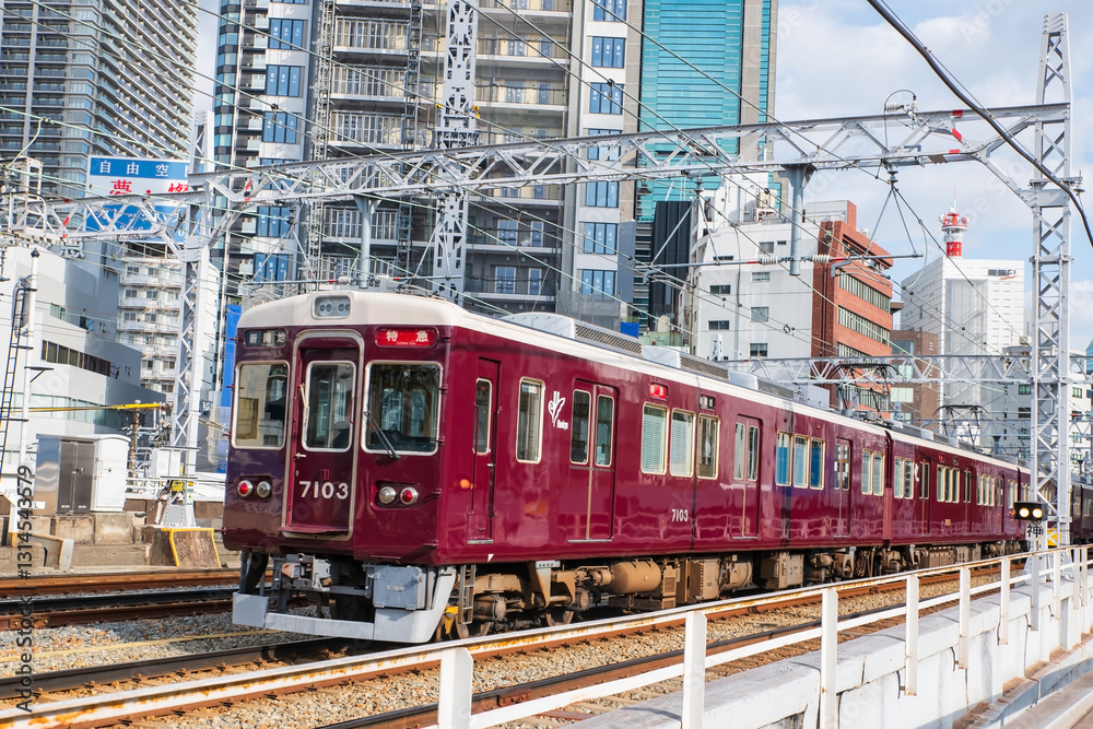 Hankyu train on railway by high rise building at Umeda area, Osaka ...
