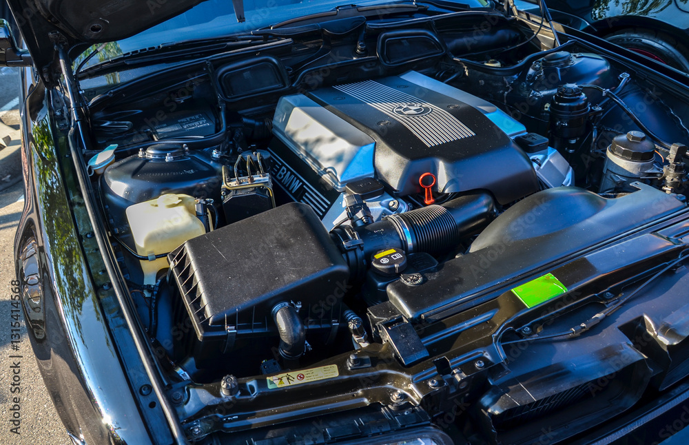 Engine bay of a BMW car with the hood open. The engine cover ...
