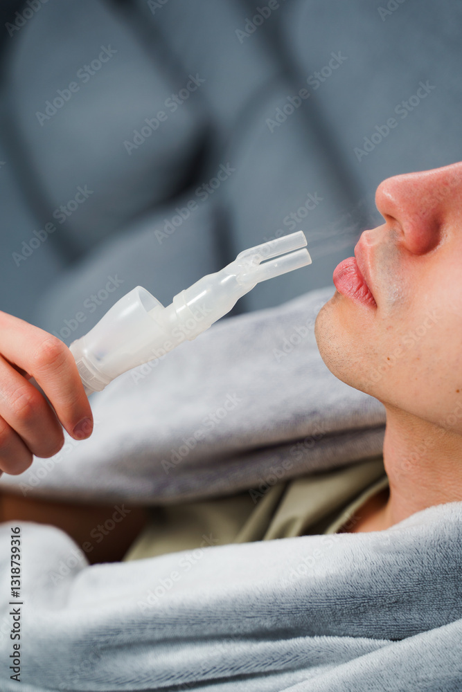 Doing nose inhalation with nebulizer at home. Young man with asthma ...