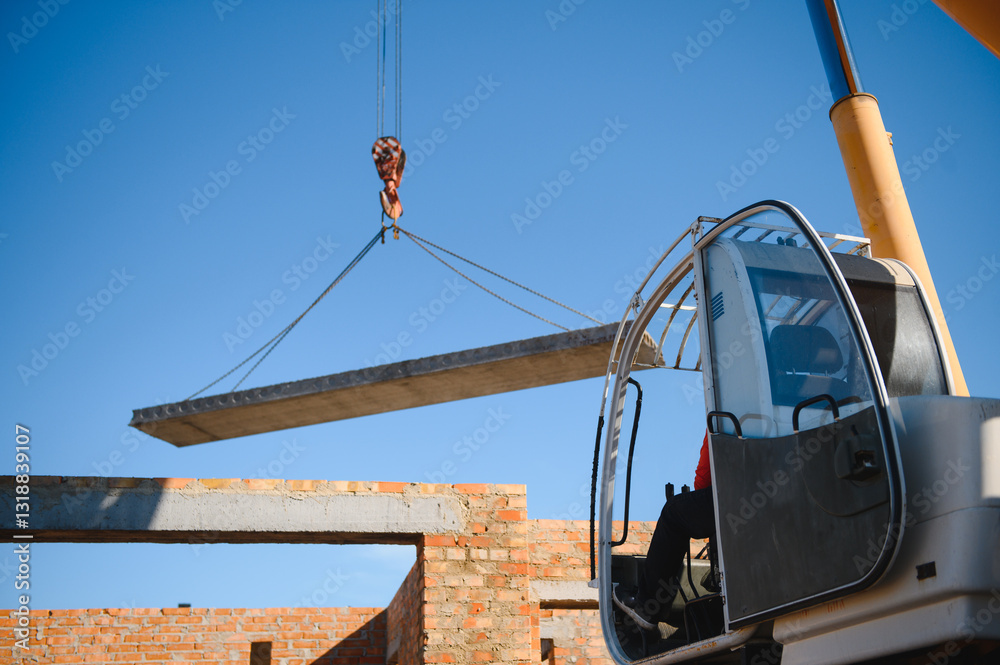 Construction site crane is lifting a precast concrete wall panel to ...