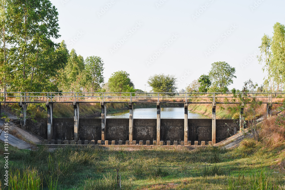 small dam or water control structure with a bridge on top. The dam ...