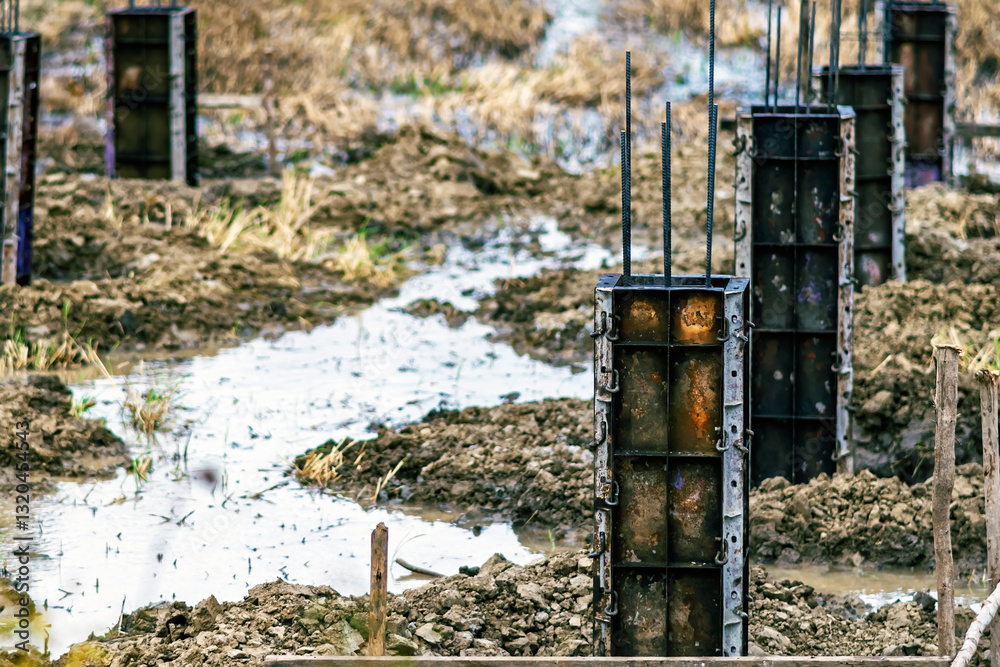 Construction of concrete pillars in paddy field. Formwork with ...