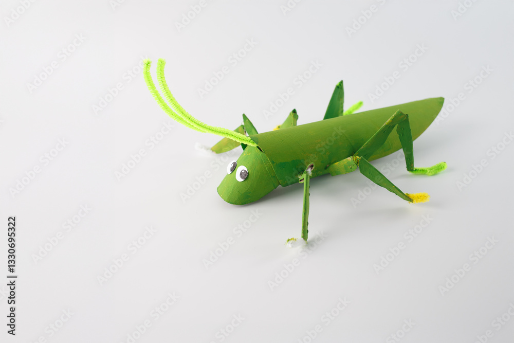 A creative craft model of a grasshopper featuring a painted green ...