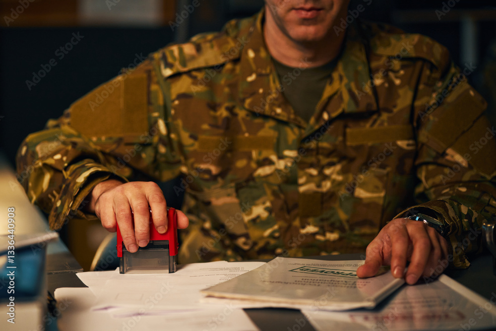 Military officer wearing camouflage uniform and using stamp on ...
