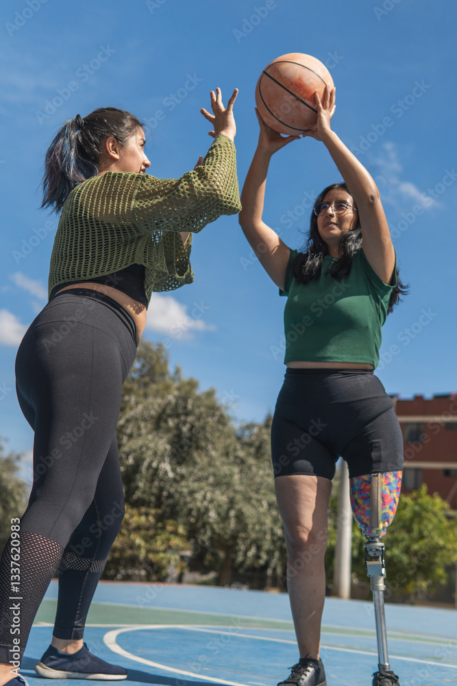 Young women playing basketball, one with prosthetic leg, embracing ...