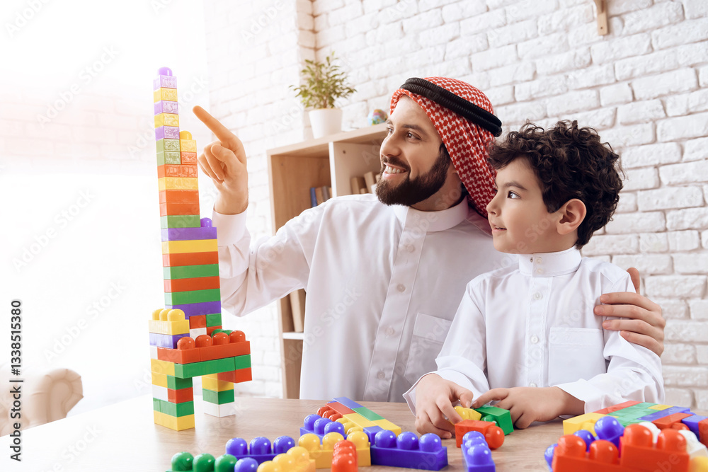 Arab man with little boy builds tower of colored plastic blocks. Stock ...