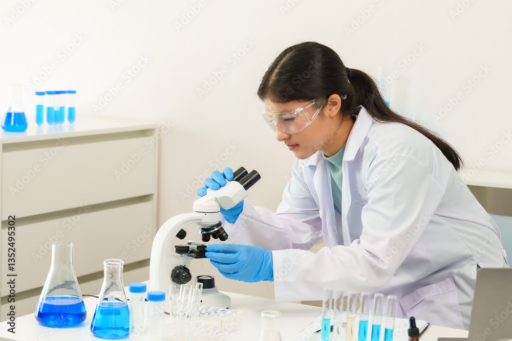 Teenage caucasian girl wearing safety goggles and gloves bending over ...