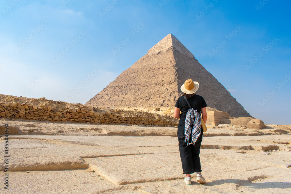 Back view of woman looking at Great Pyramids of Chephren and Cheops ...