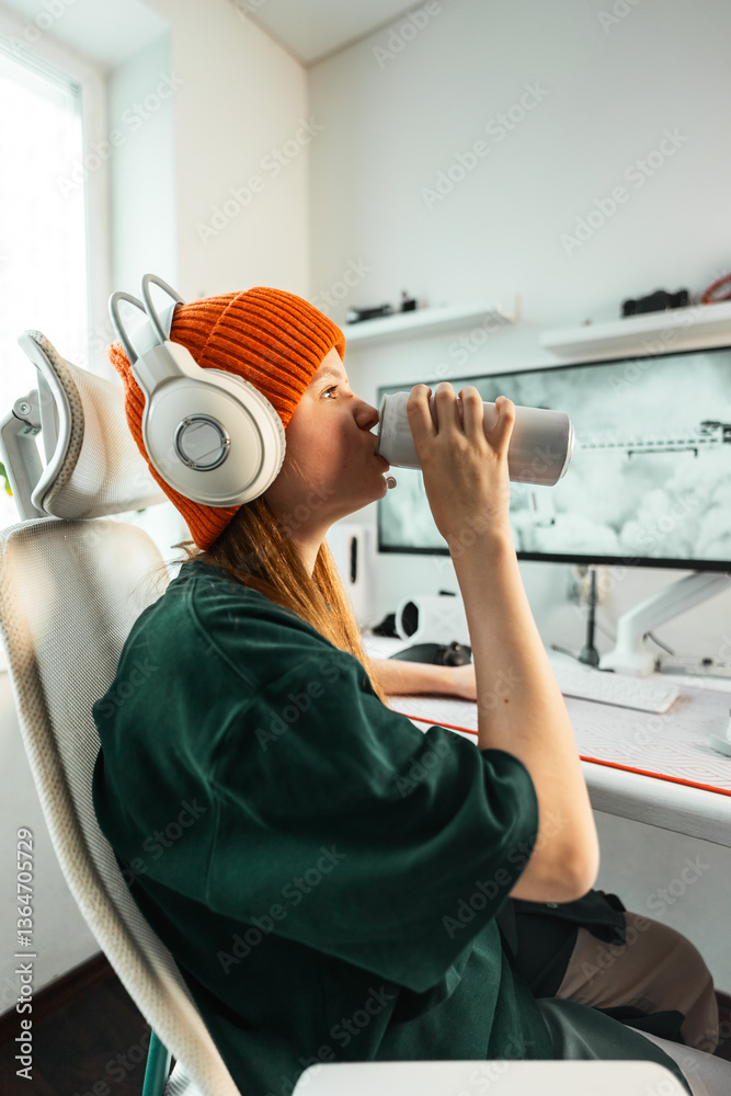 Gamer in high-tech gaming station enjoys refreshing energy drink ...