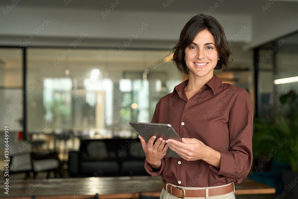 Smiling young Hispanic professional business woman using tablet ...