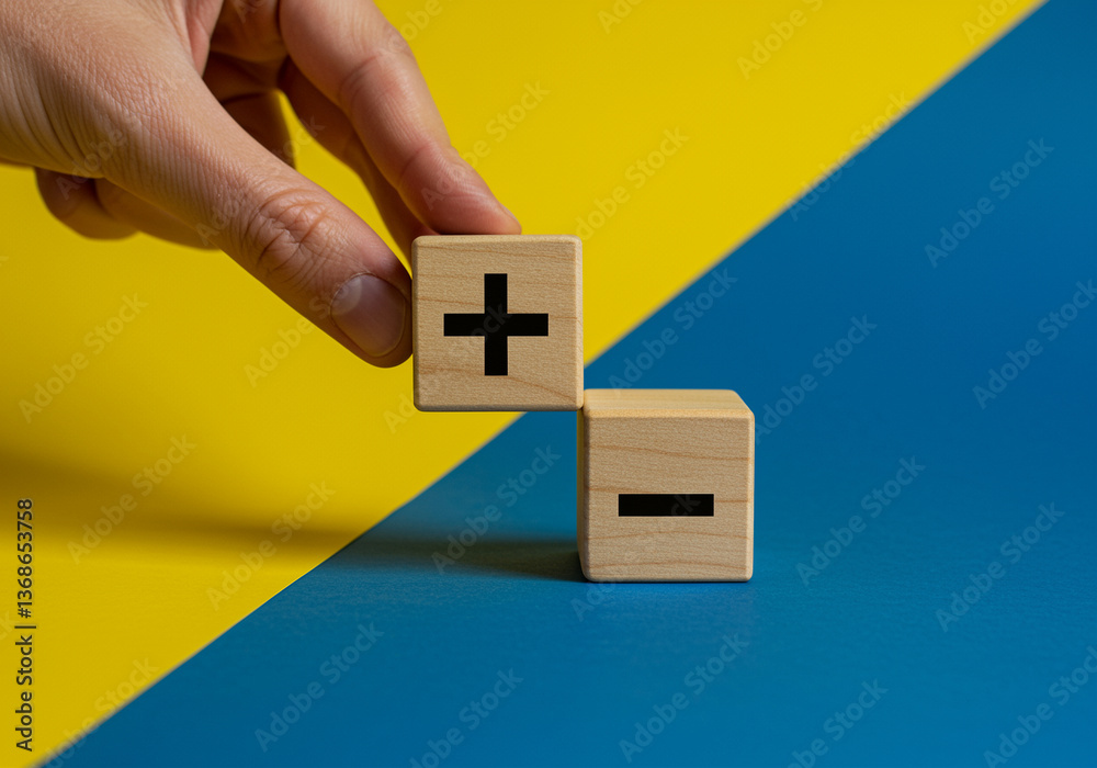 Wooden blocks showing plus and minus signs on yellow and blue ...