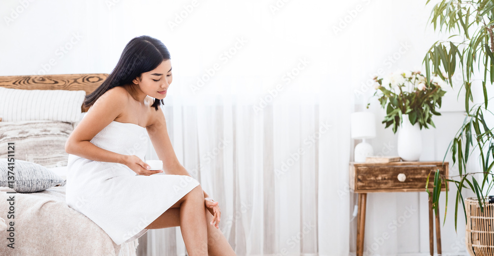 Sensual asian girl applying moisturizer on her beautiful legs after ...