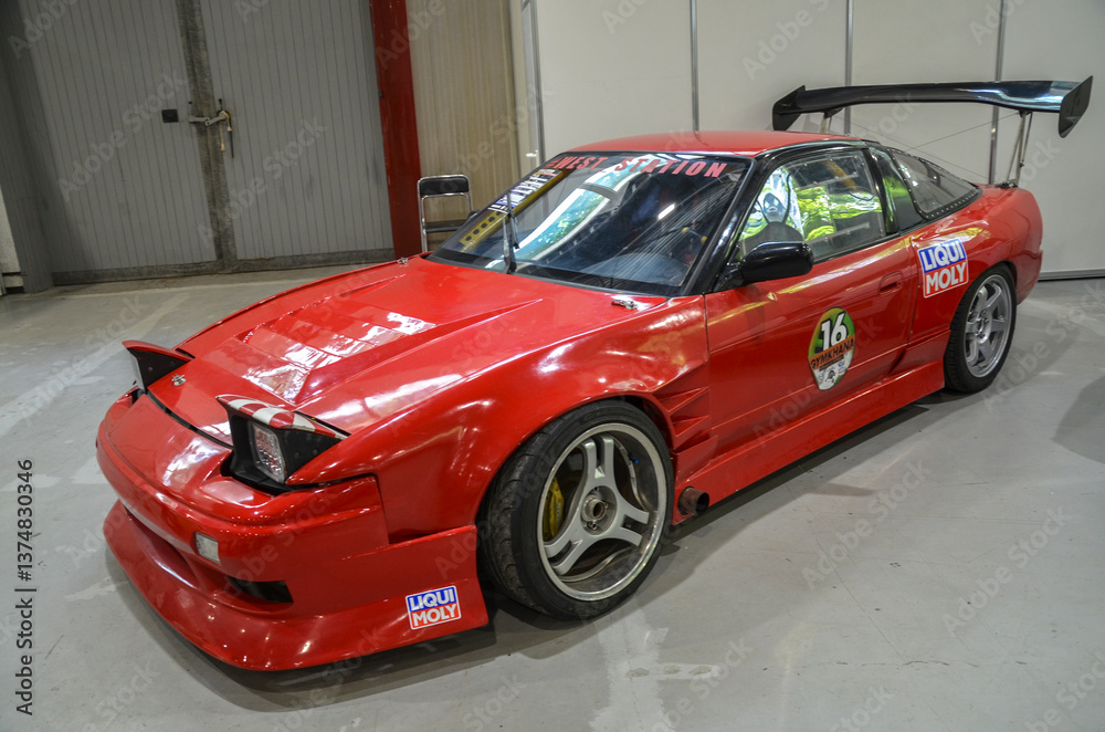 Heavily modified red Nissan 200SX S13 with large rear wing and ...