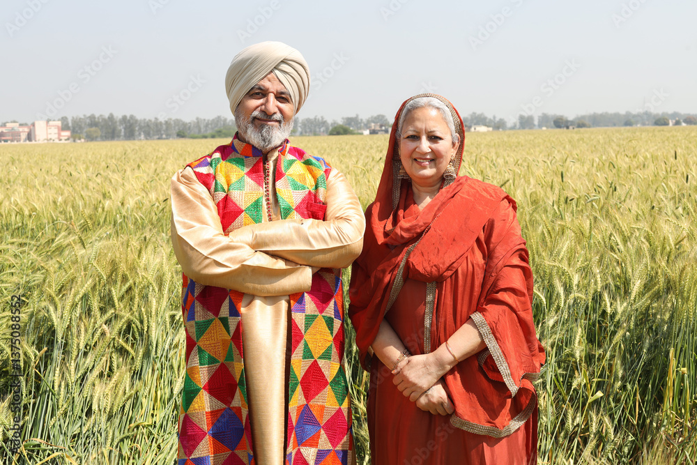 Punjabi sikh senior couple standing together outdoor at agriculture ...