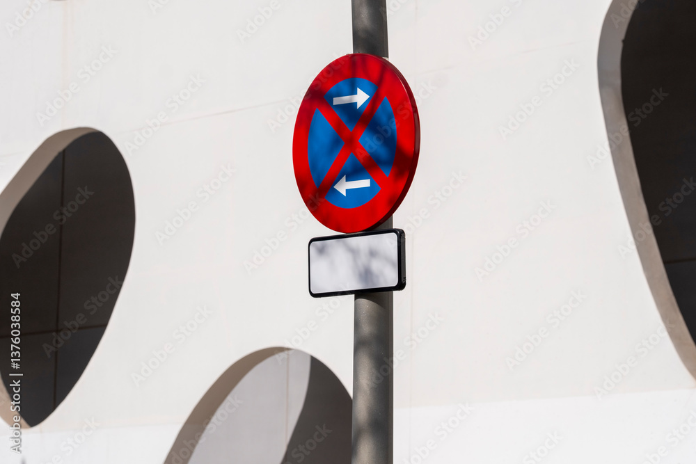 No parking sign mounted on modern facade with circular patterns, urban ...