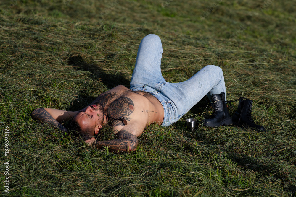 Strong farmer man sitting in a sunlit field. Muscular farmer rest on ...