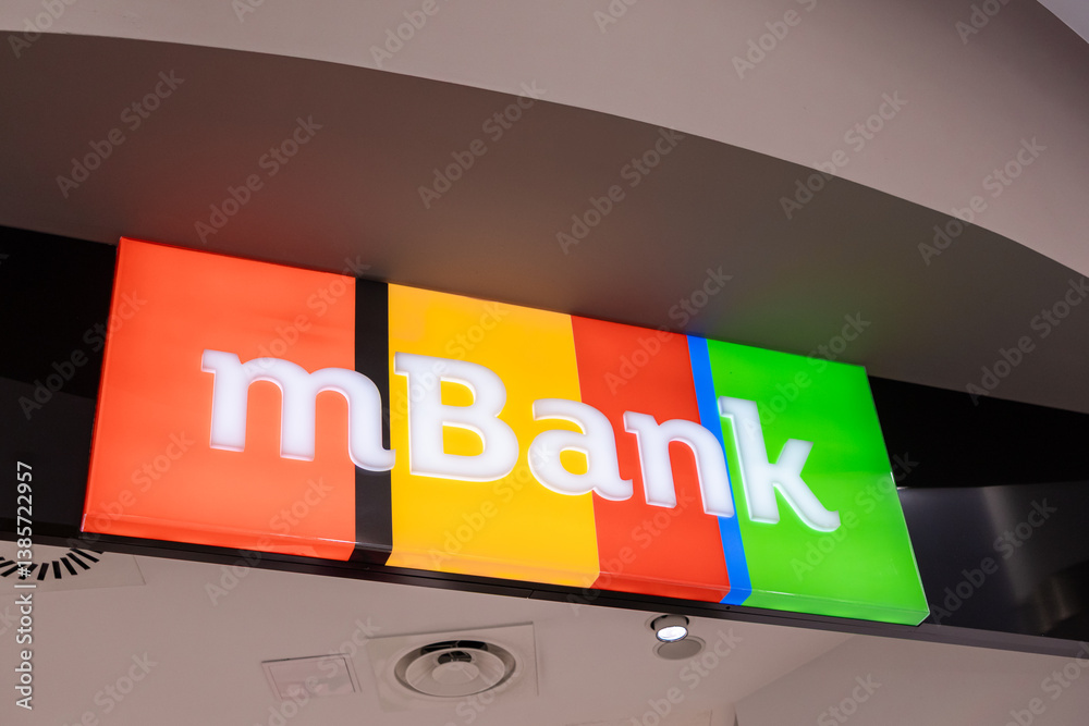 Poznan, Poland - March 15, 2025: mBank branch entrance with illuminated colorful logo in red ...
