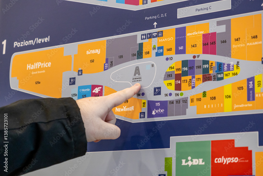 Poznan, Poland - March 15, 2025: Person pointing at shopping mall ...