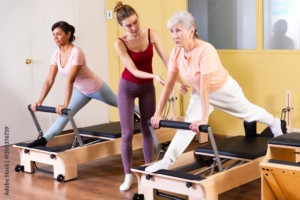 Two health conscious women of different ages perform a Pilates exercise ...