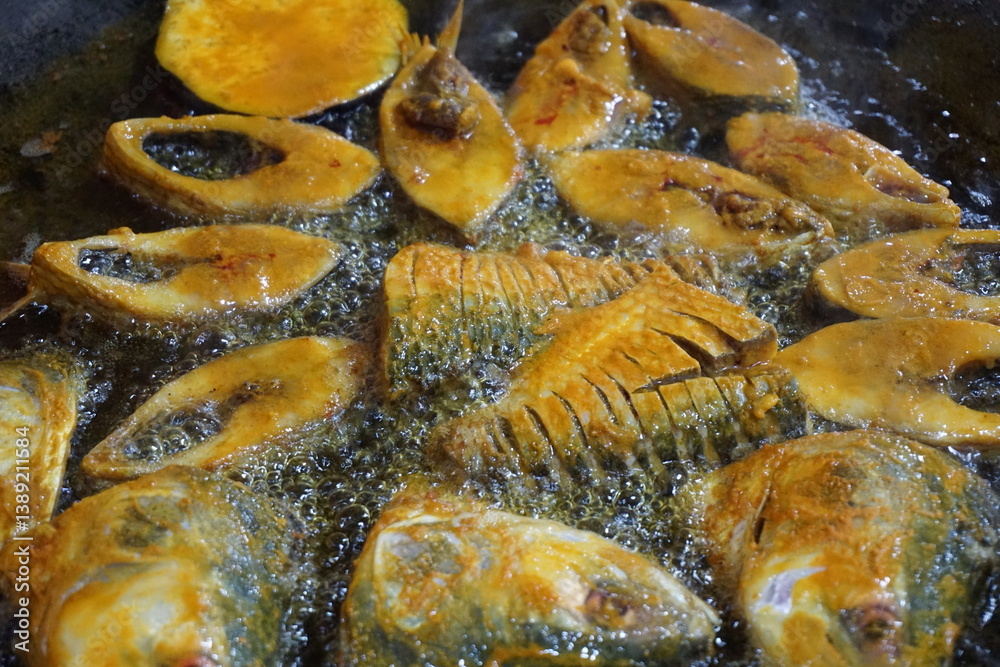 Stock-Foto „Hilsha fish is fried in a big pan along with shrimp and ...