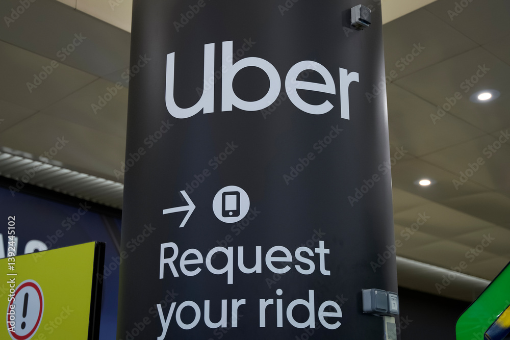 A black pillar inside a transportation terminal displays a bold Uber ...