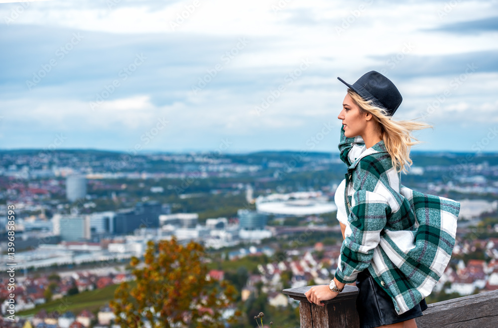 Gen Z woman escaping from city life on a hilltop with a view over ...