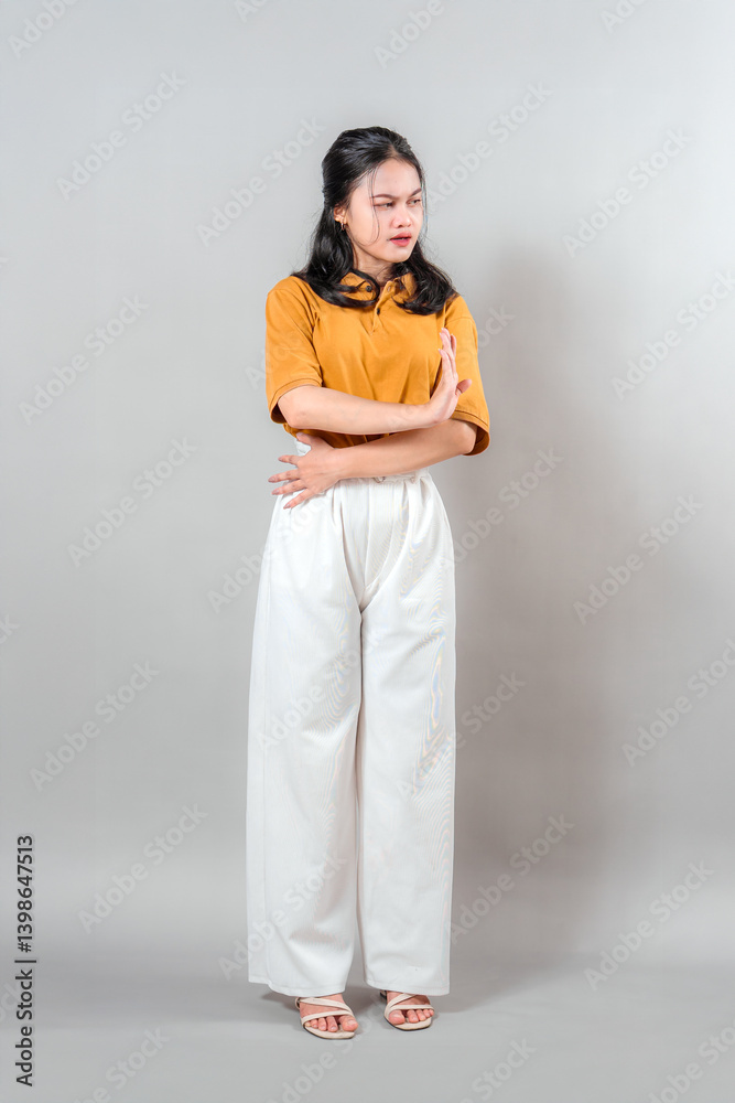 Asian woman showing a displeased facial expression, crossing her arms ...