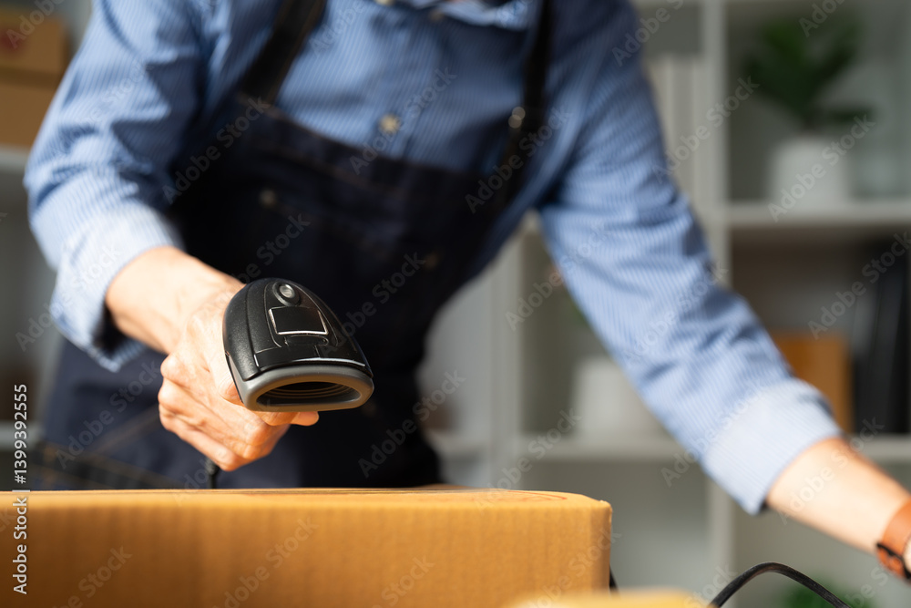 Small business owner scanning packages with a barcode scanner in a ...