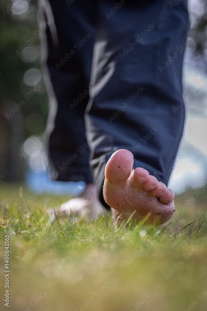Human feet of an adult male walking barefoot in a forest as a form of ...