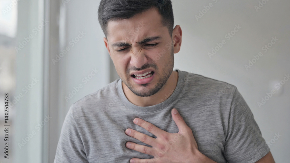 Chest Pain and Discomfort: A young man clutches his chest, his face ...