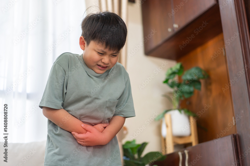Portrait of sick unhappy little child asian boy touching belly stomach ...