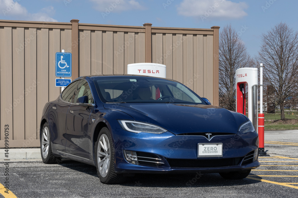 Tesla EV electric vehicle at a supercharger. Tesla products include ...