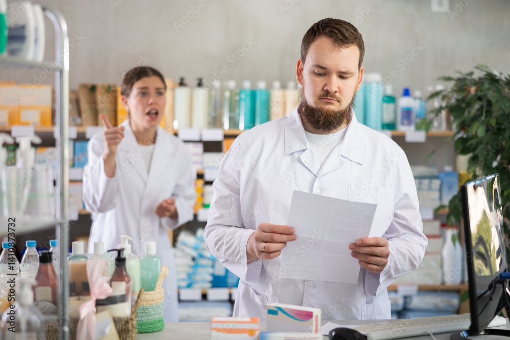 Confused male pharmacist employee during argument with boss ...