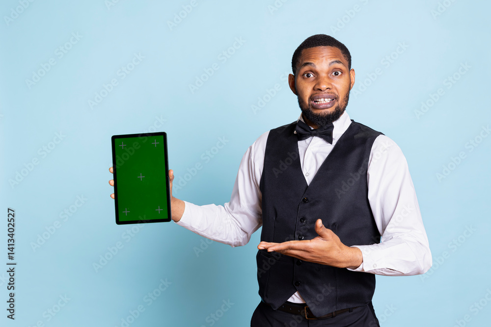 Bellman hotelier showing a tablet with green screen display in studio ...
