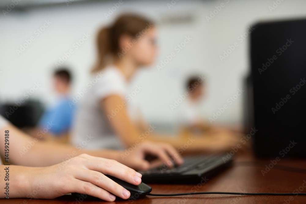 Hands of unrecognizable pupil using computer in classroom, pushing ...
