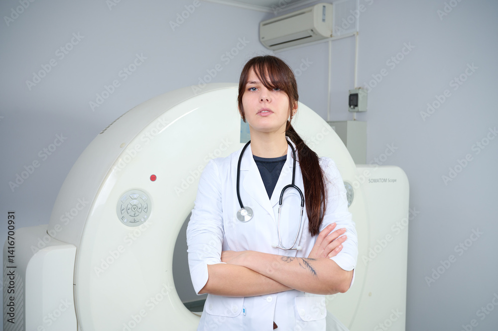 Young female radiologist staying in scanning room holding CT film ...