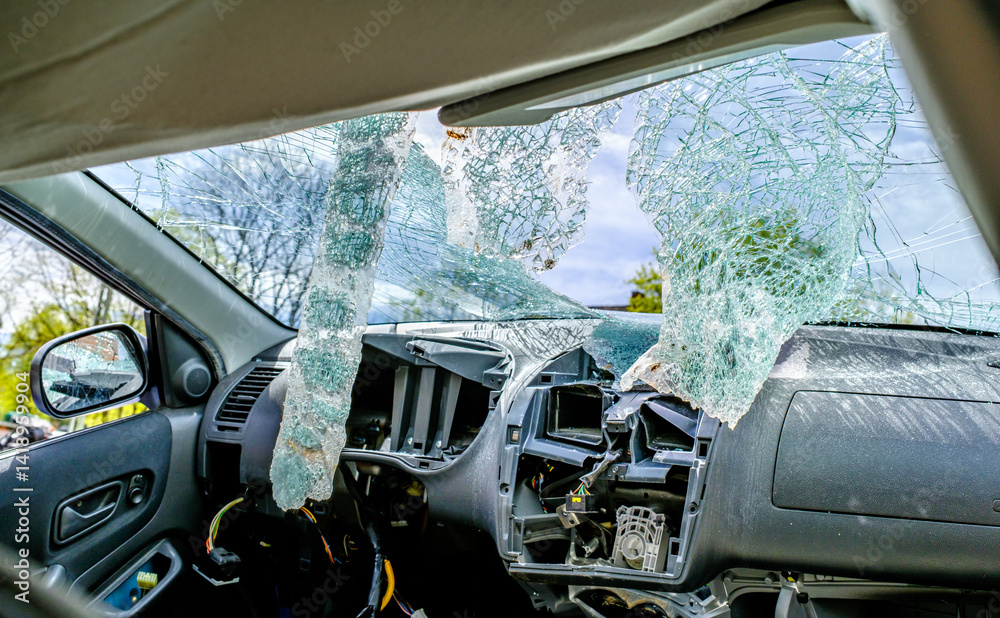 Damaged blue car with shattered windshield in a junkyard during ...