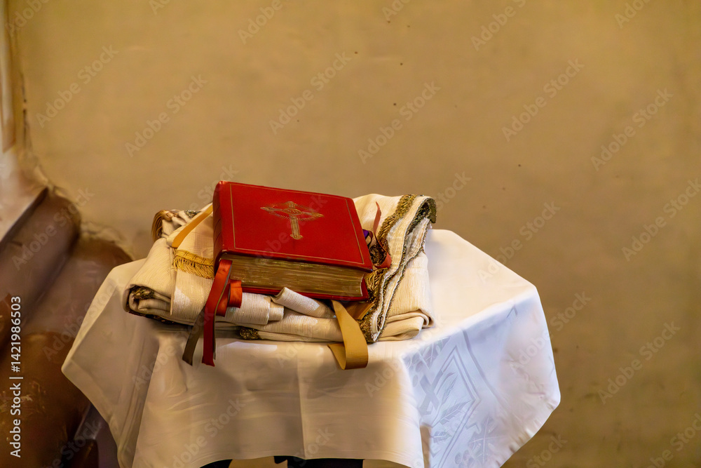 small round table covered with a white tablecloth, on which a red ...