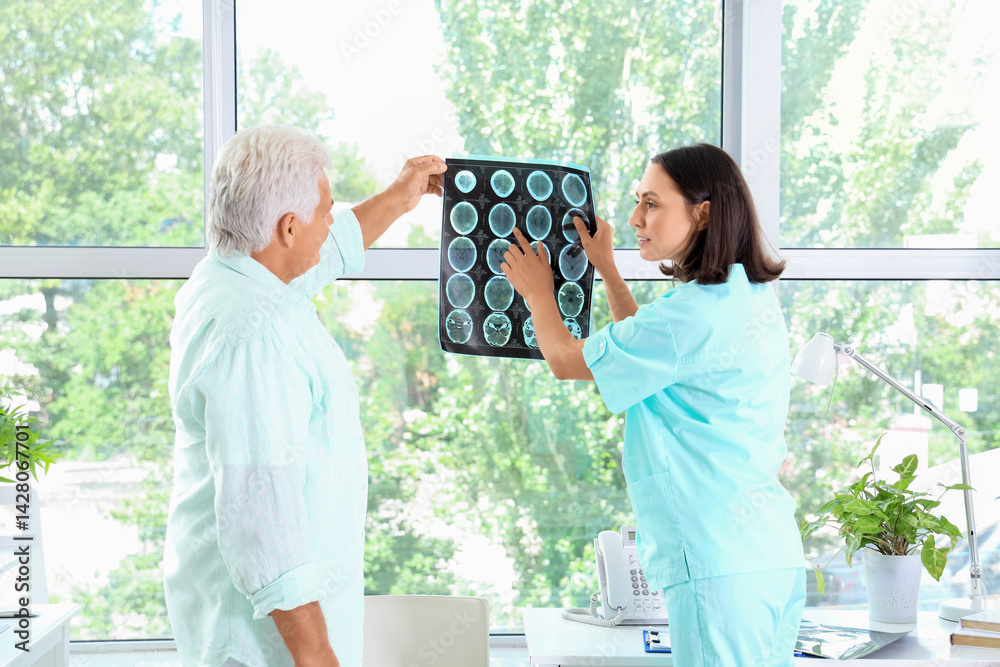 Female doctor showing x-ray scan to senior patient in medical office ...