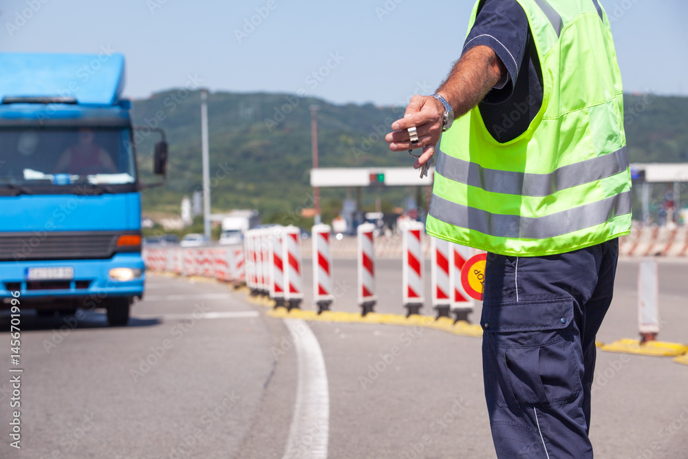 Highway traffic police officer wearing a reflective vest signals a blue ...