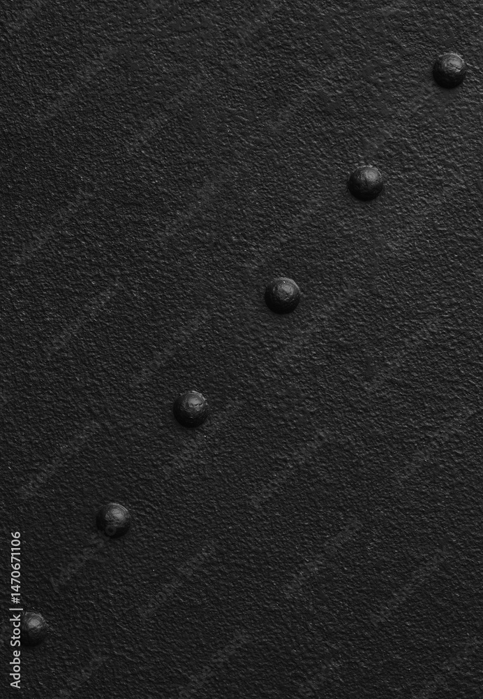 Textured black metal surface with rivets creating a minimalist and bold ...