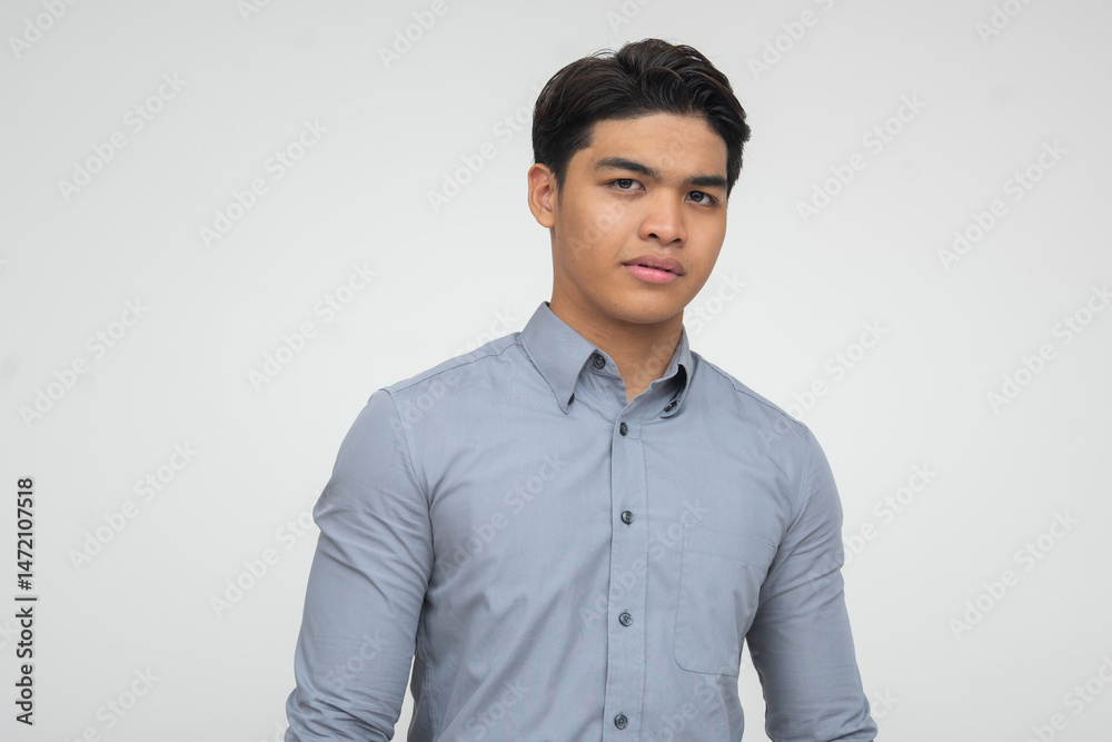 Young Southeast Asian man looking uneasy and slightly awkward, with a ...